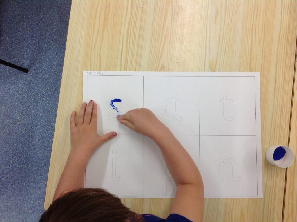 Writing letters using finger paints | Aith Primary Department